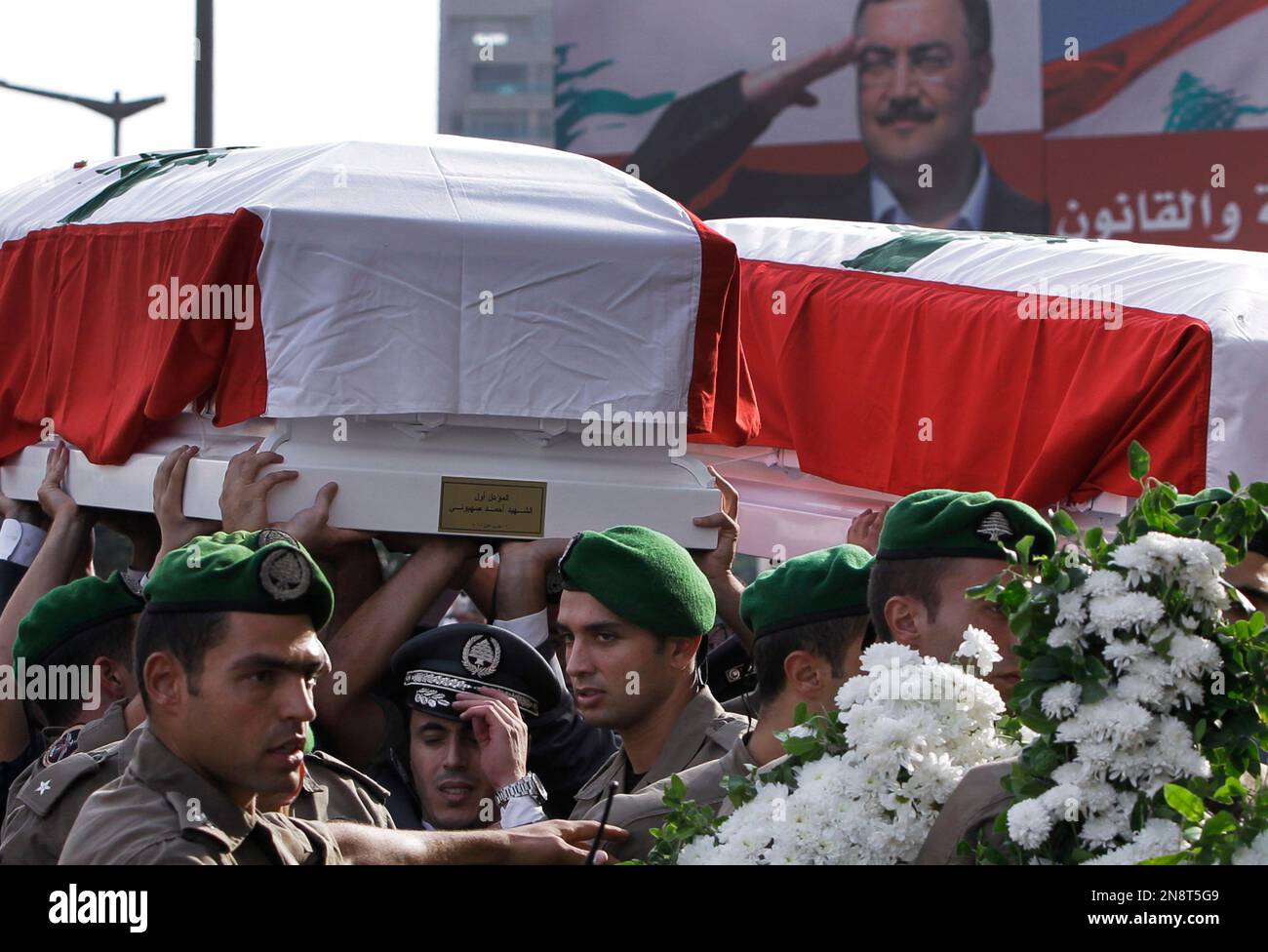Members of Lebanese police intelligence division units carry the flag ...