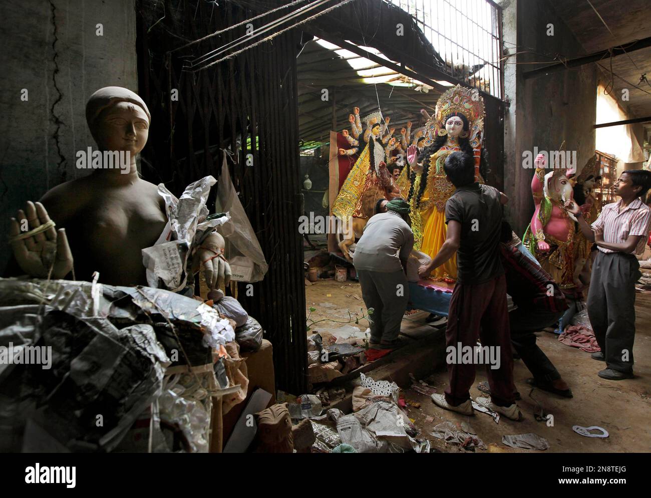Indian workers carry an idol of Hindu goddess of valor Durga from a ...