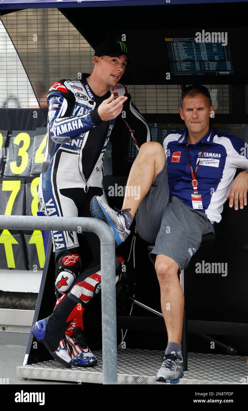 MotoGP rider Ben Spies of the U.S. talks to his crew at pit wall before ...