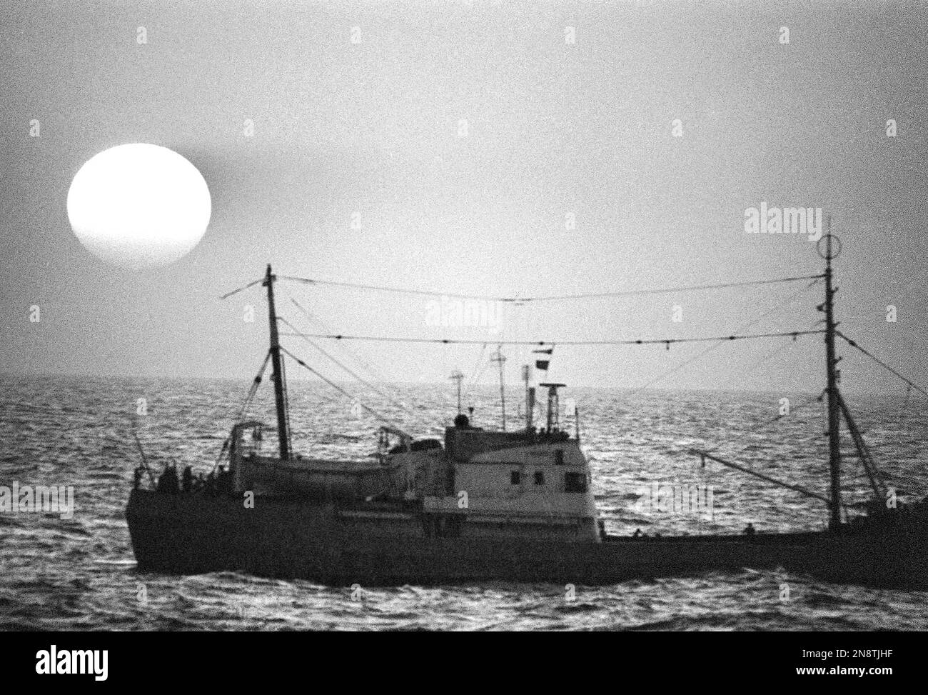 The sun sets behind portion of the Soviet trawler Barograph in the Gulf ...