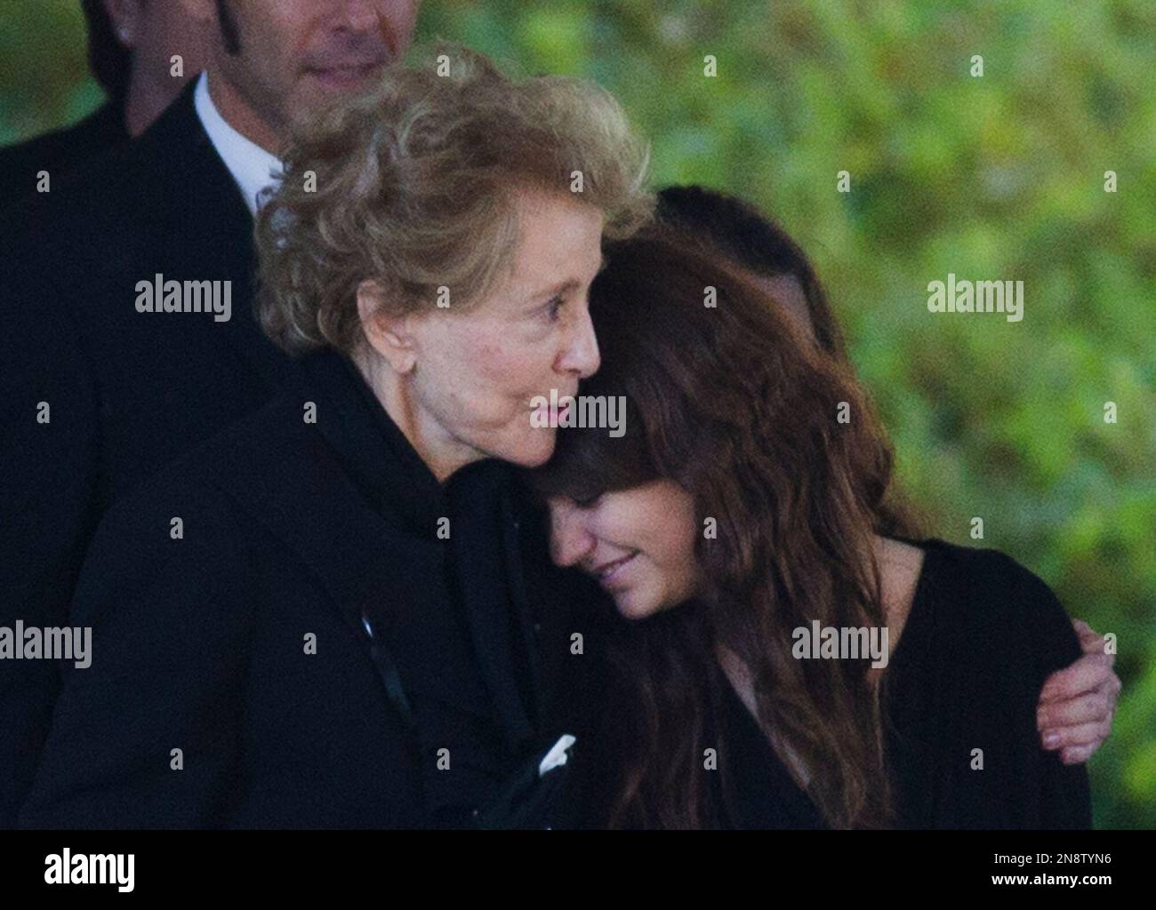Joan Specter, left, hugs a woman as she and others leave Har Zion ...
