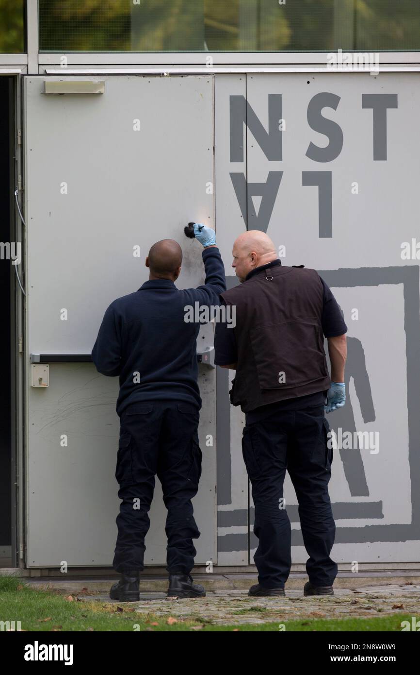 Forensic experts dust the inside of a back door for fingerprints at ...