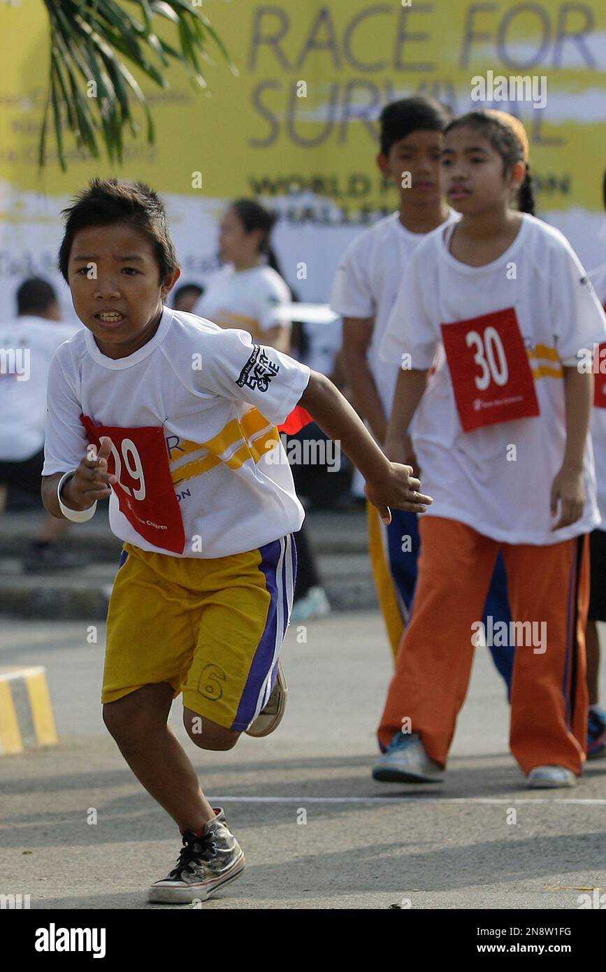 A Filipino boy dashes out of the starting line during a relay marathon ...