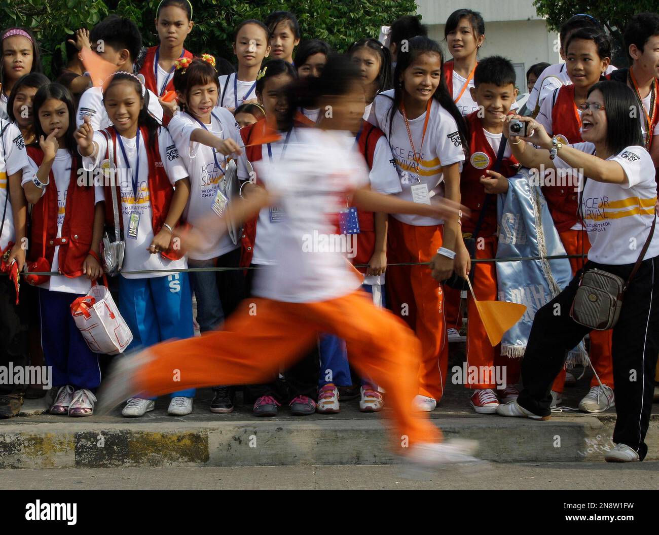 Filipino school children cheer as their team finishes part of a relay ...