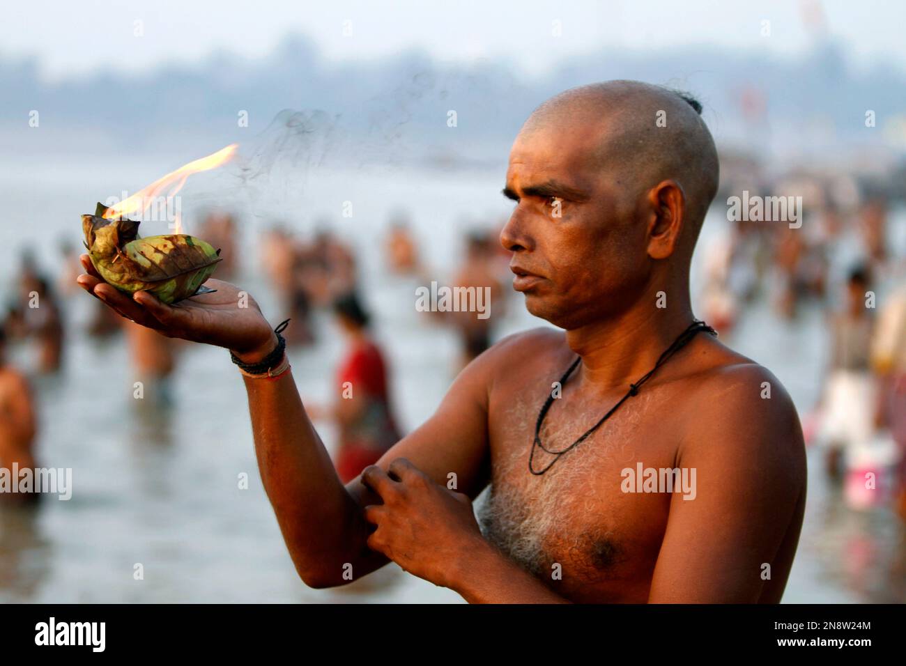 A Hindu devotee offers prayers after taking a holy dip in the Ganges ...