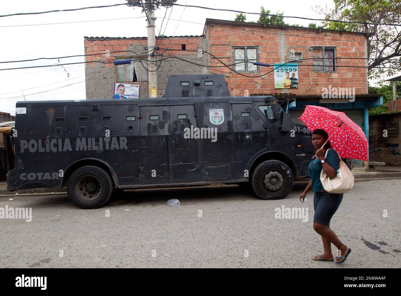 A woman walks past a police armored car during an operation to install ...