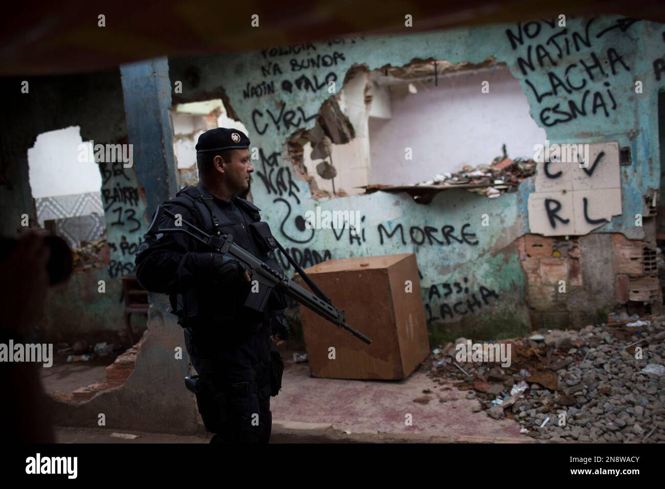 A Police officer patrols in the Maguinhos slum during an operation to ...