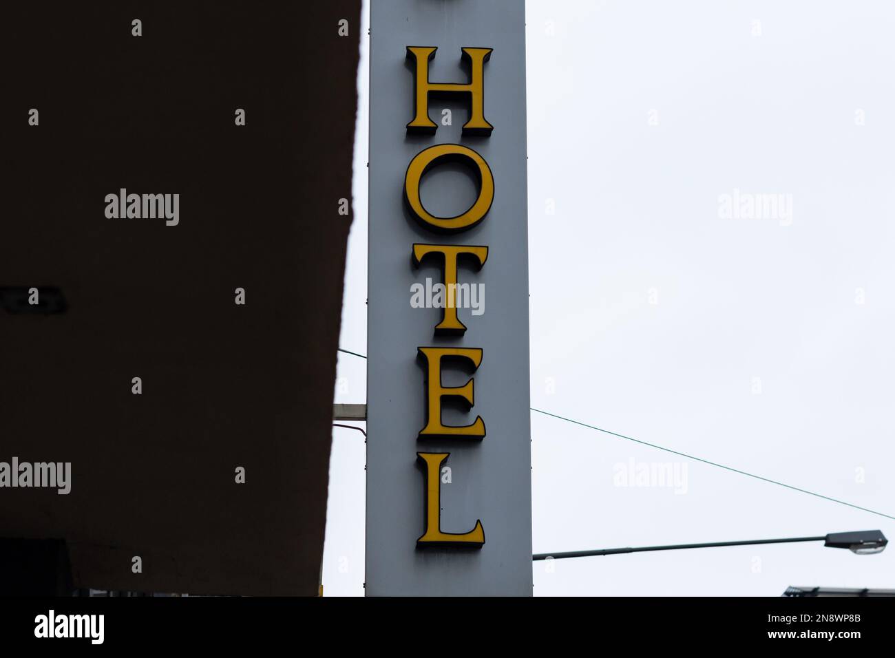 Hotel sign on a building. Yellow letters on a grey background ...