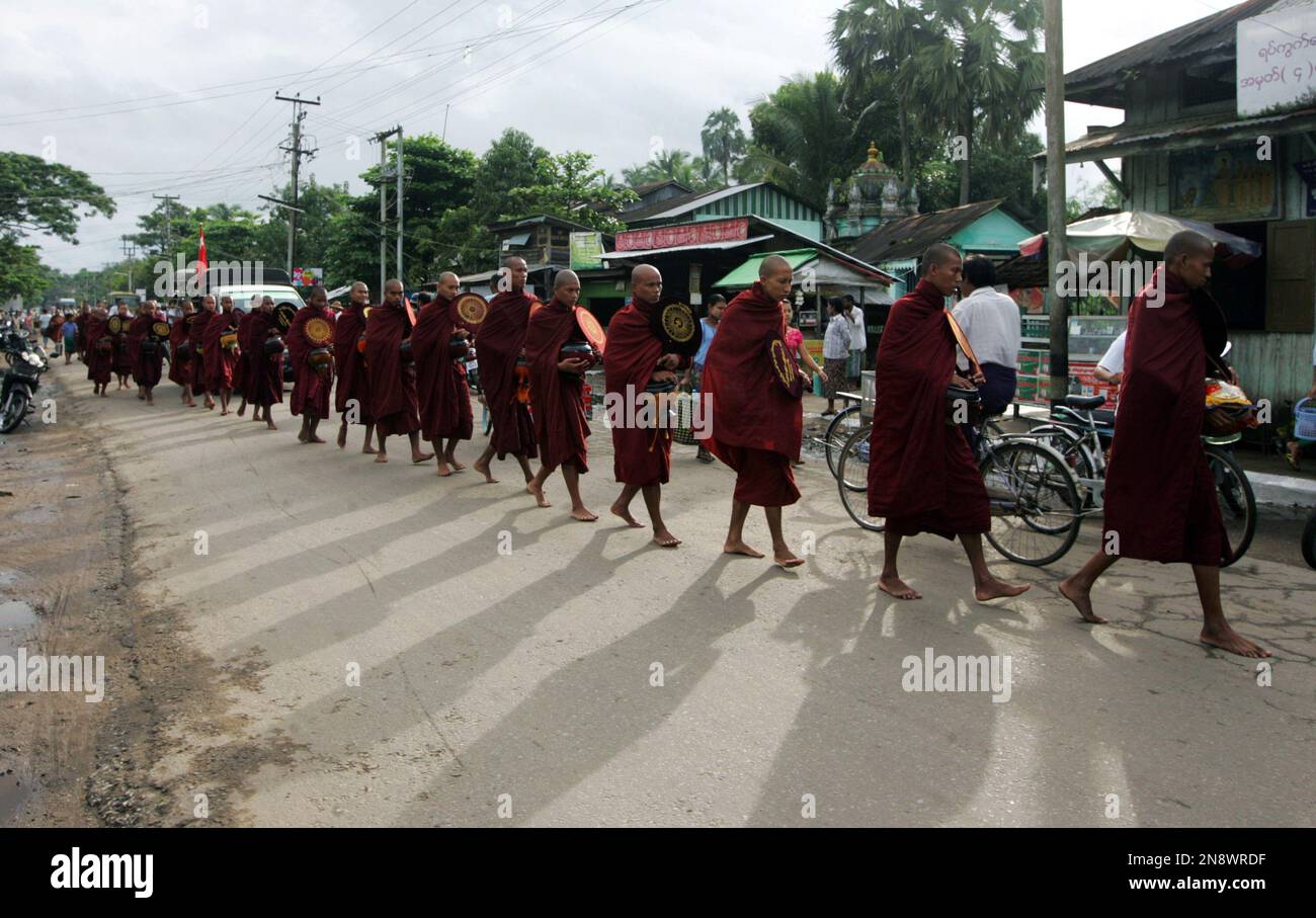 Myanmar Buddhist monks walk along a road while collecting alms in Thone ...