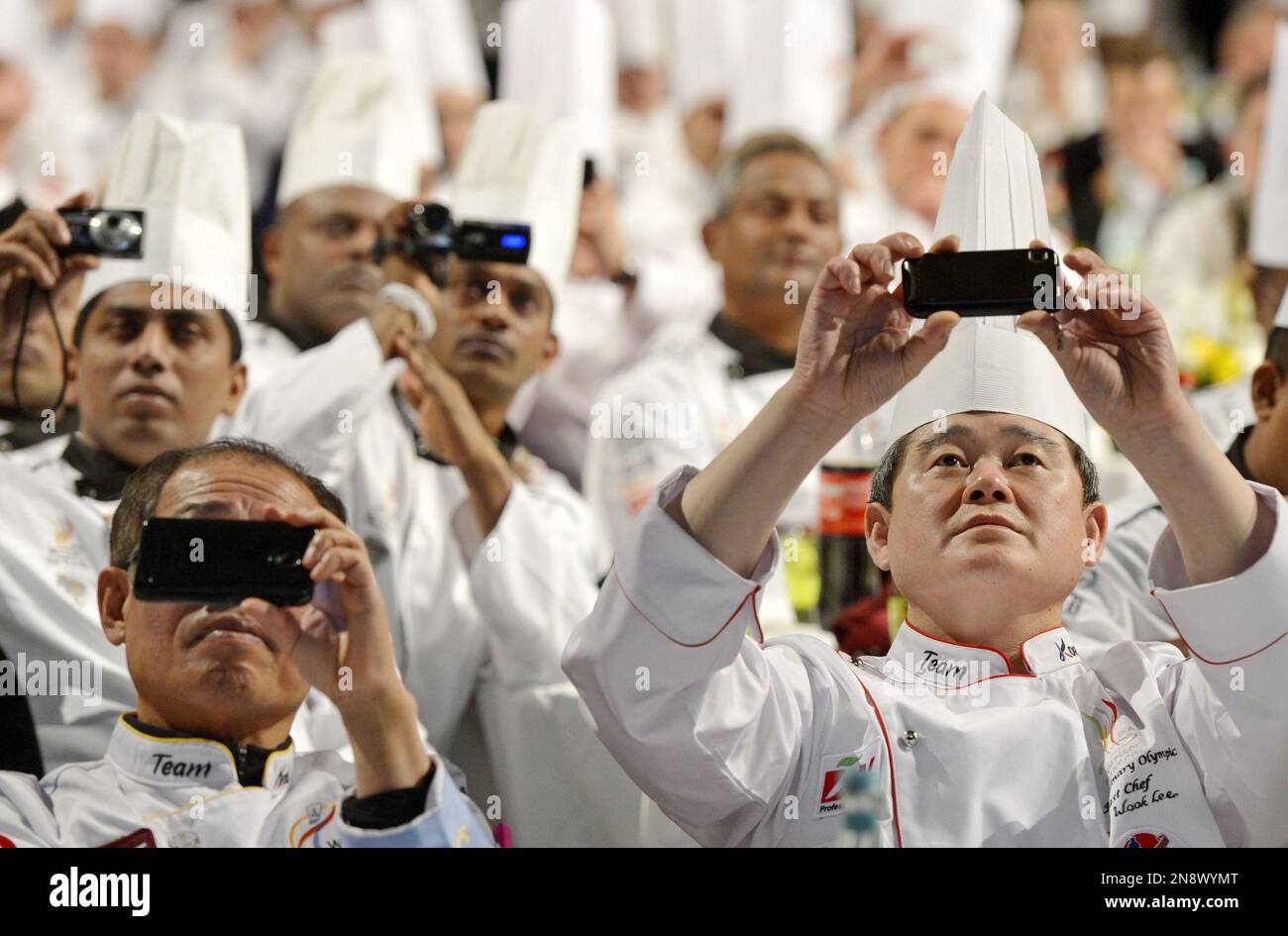 Cooks shoot photos during the Olympic medal ceremony at the ...