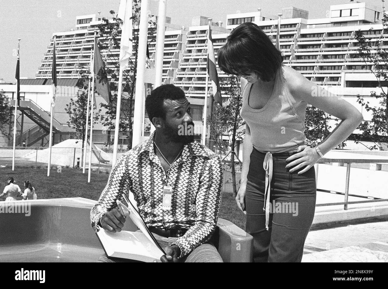 John Carlos, who broke the 200-meters record, signs an autograph for a girl in front of the ...