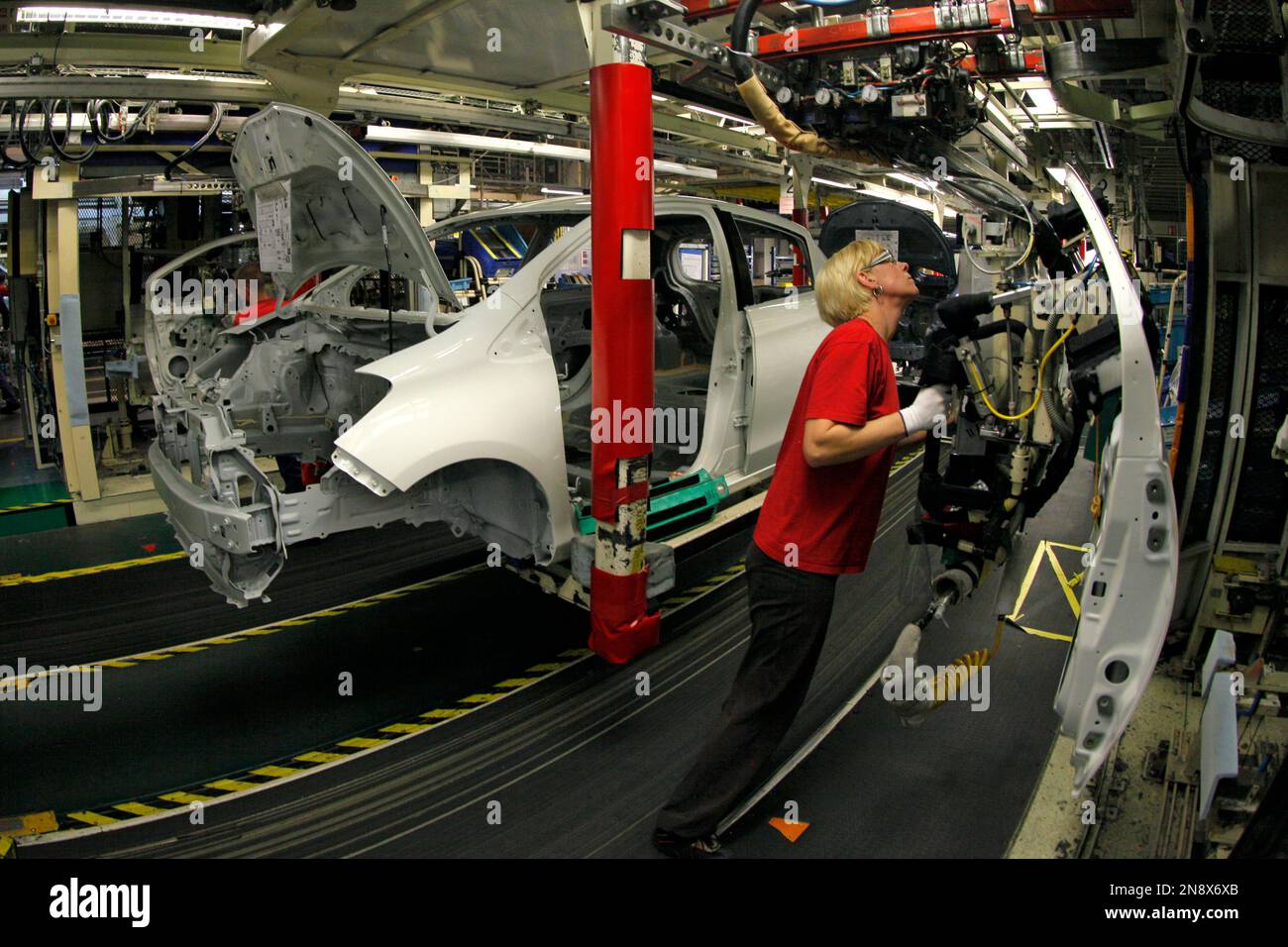 An employee works on a Toyota Yaris car on the assembly line at the ...