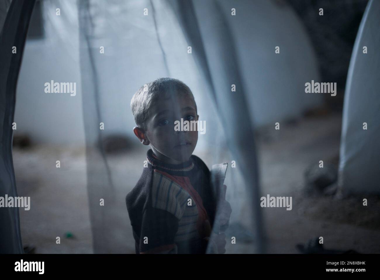 A Syrian boy, who fled his home with his family due to fighting between ...