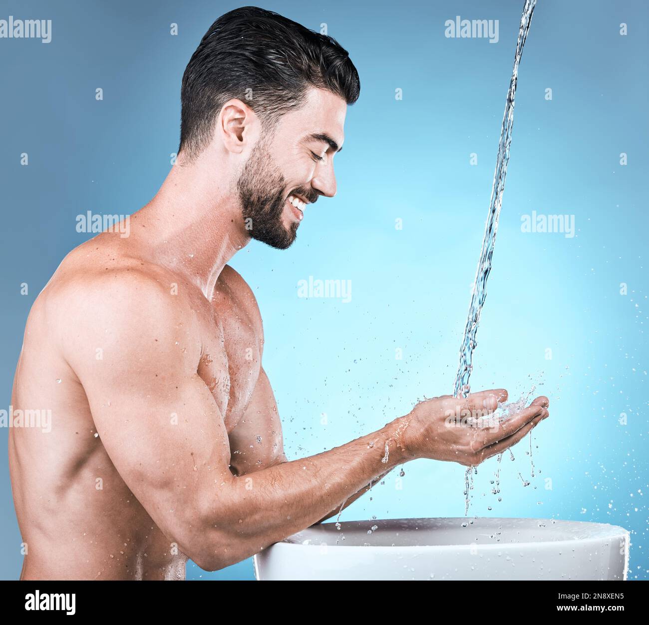Water splash, skincare and man cleaning hands in studio isolated on ...