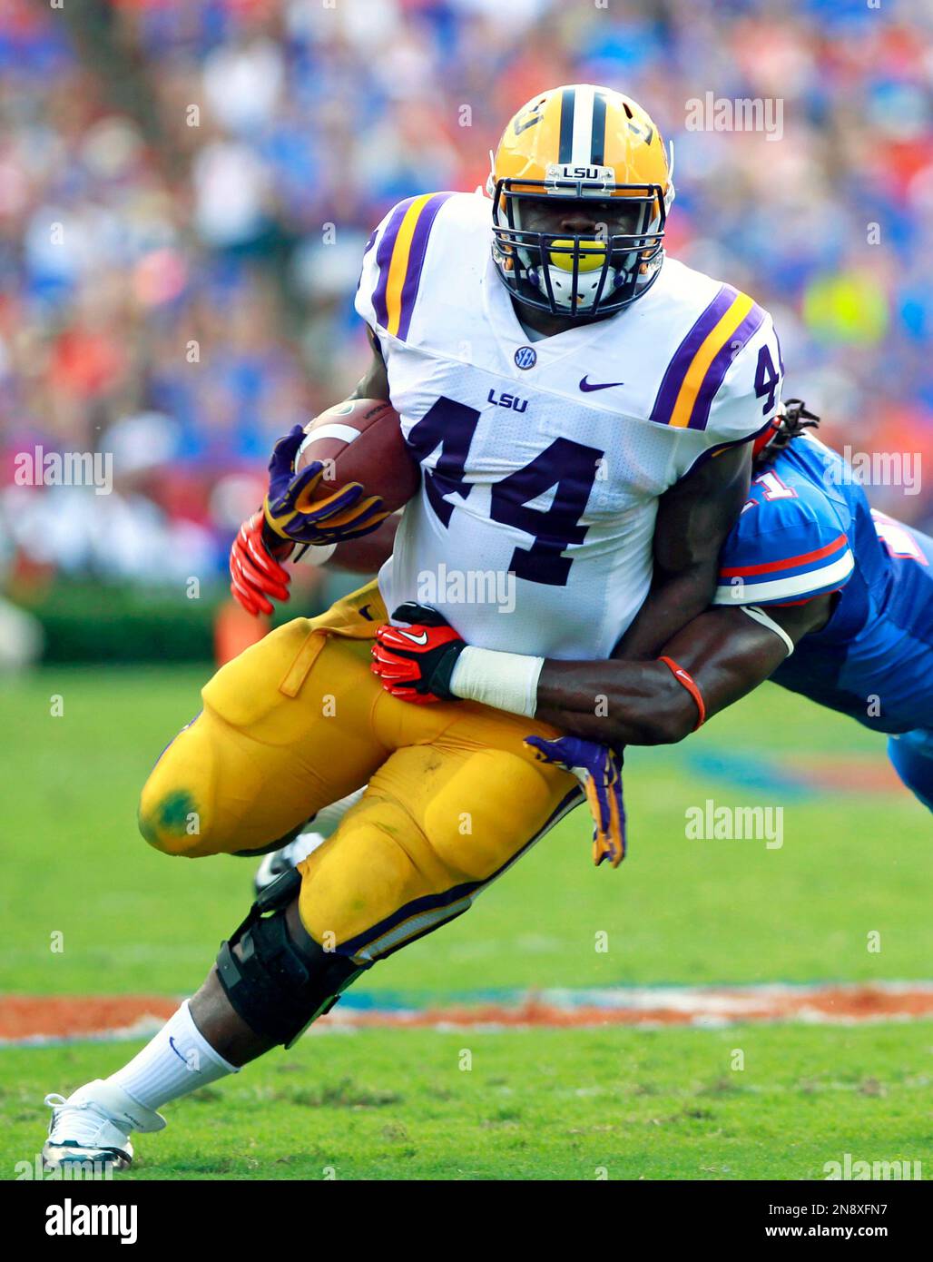 LSU fullback J.C. Copeland (44) is stopped by Florida linebacker Neiron ...