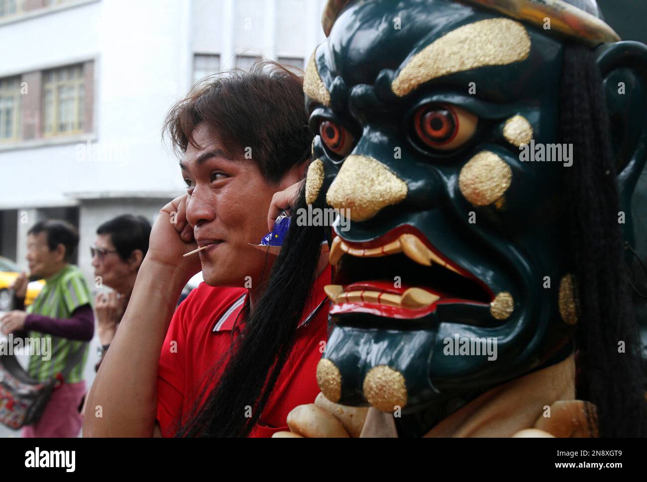 A Taiwanese man smiles next to a Taiwanese local god during the Taipei ...