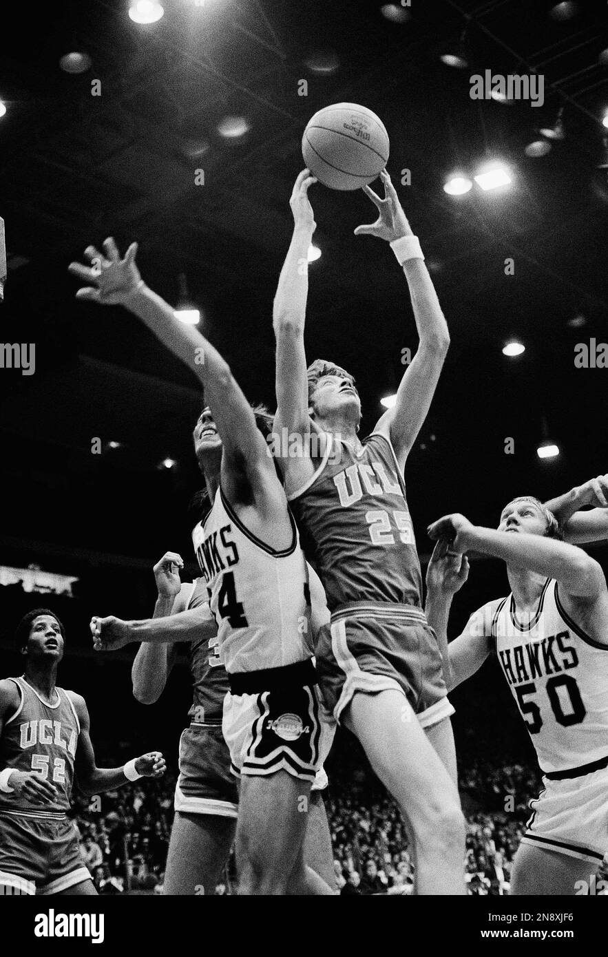 CHICAGO, IL., Jan 18, 1974 - Pete Trgovich (25) of UCLA rises above two ...