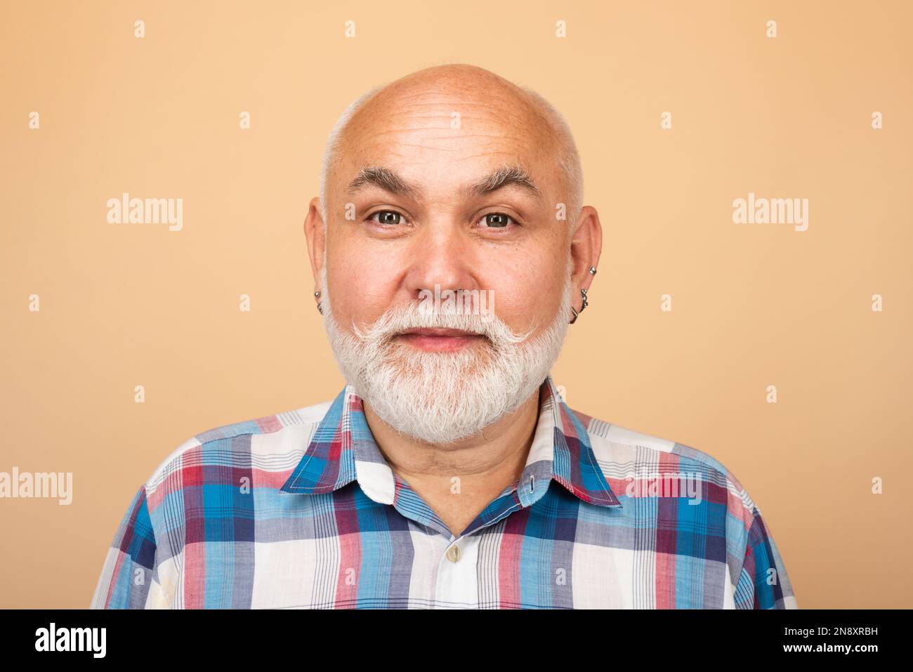 Grandfather pensioner, retiree concept. Mature bald man with grey beard on studio background ...