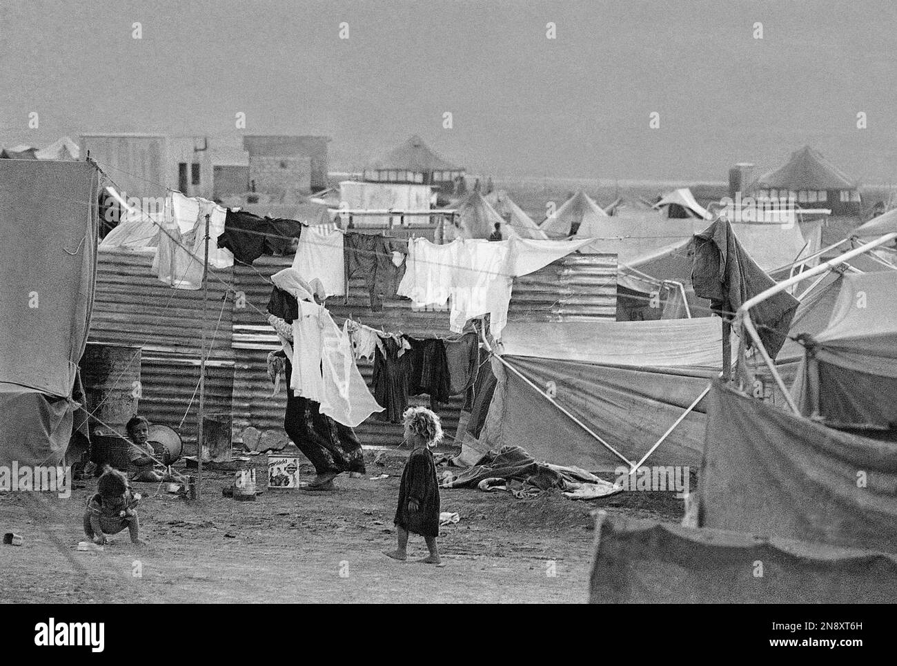 Little children play amidst lines of laundry drying out at Baqaa Camp ...