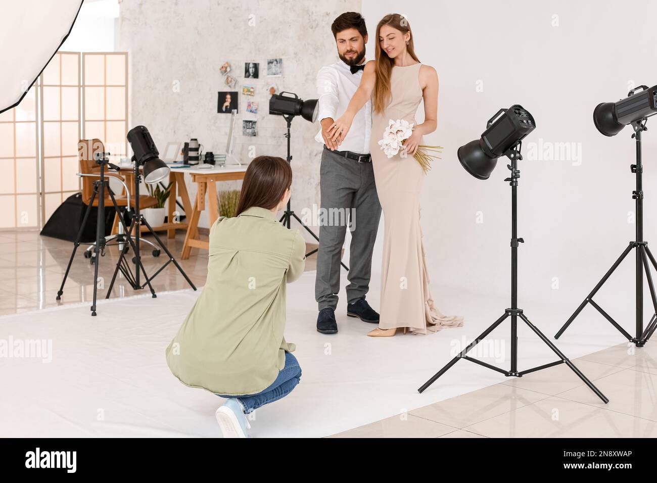 Female photographer taking picture of couple in studio Stock Photo - Alamy