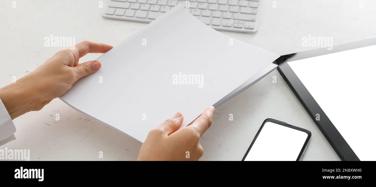 Woman holding blank paper sheets at workplace in office Stock Photo - Alamy