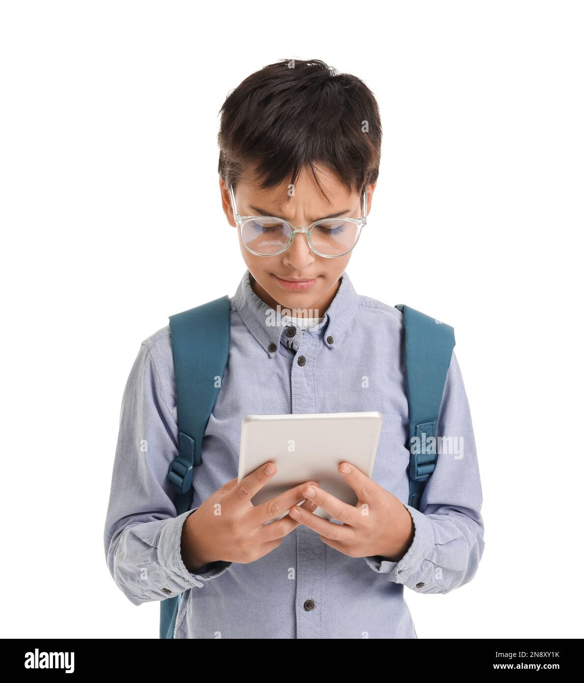 Upset little schoolboy using tablet computer on white background Stock ...