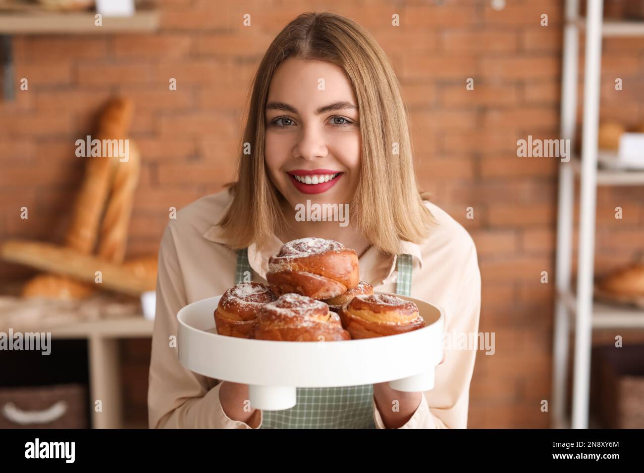 Female baker with tray of tasty buns in kitchen, closeup Stock Photo ...