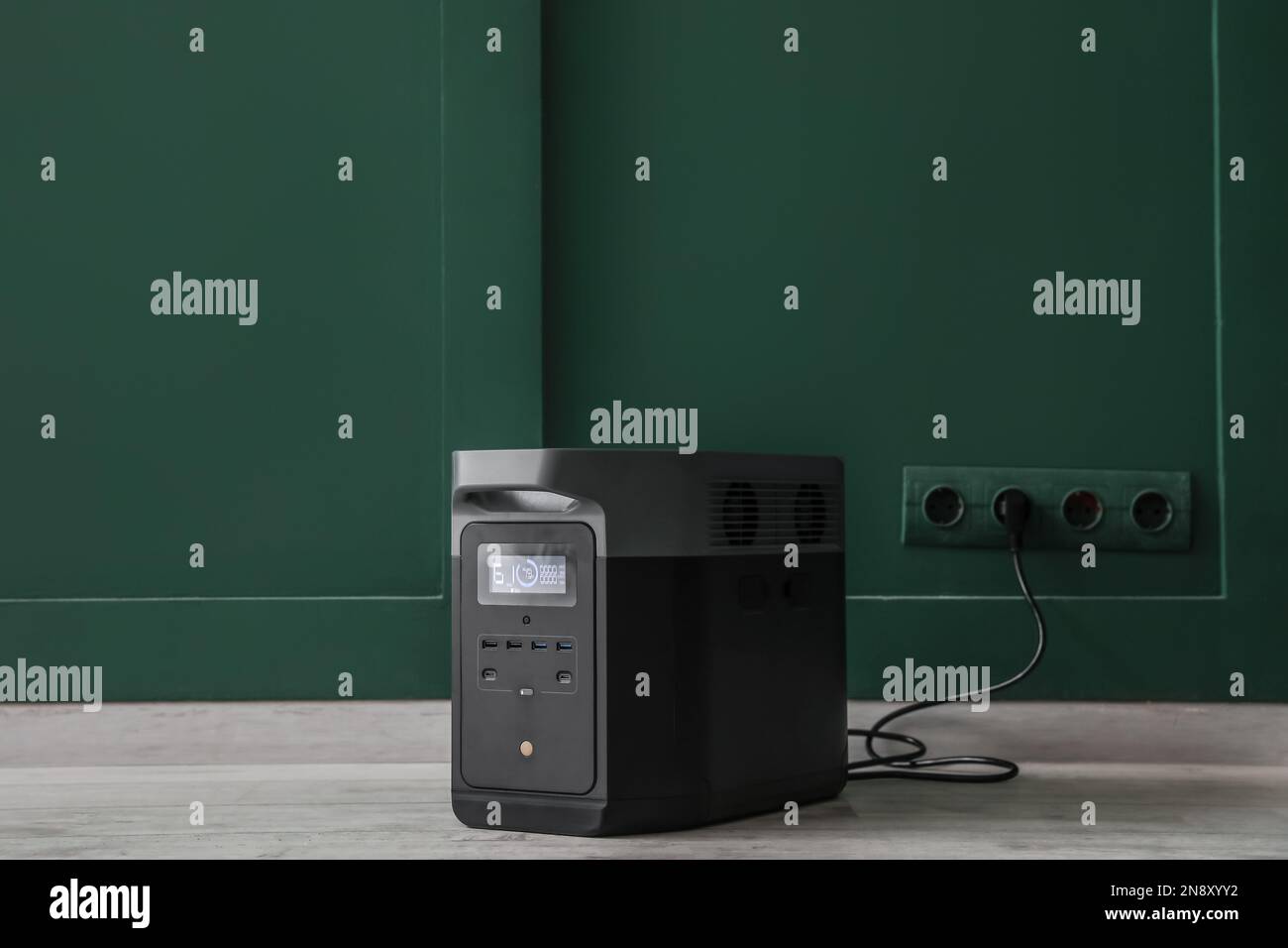 Portable power station near green wall Stock Photo - Alamy