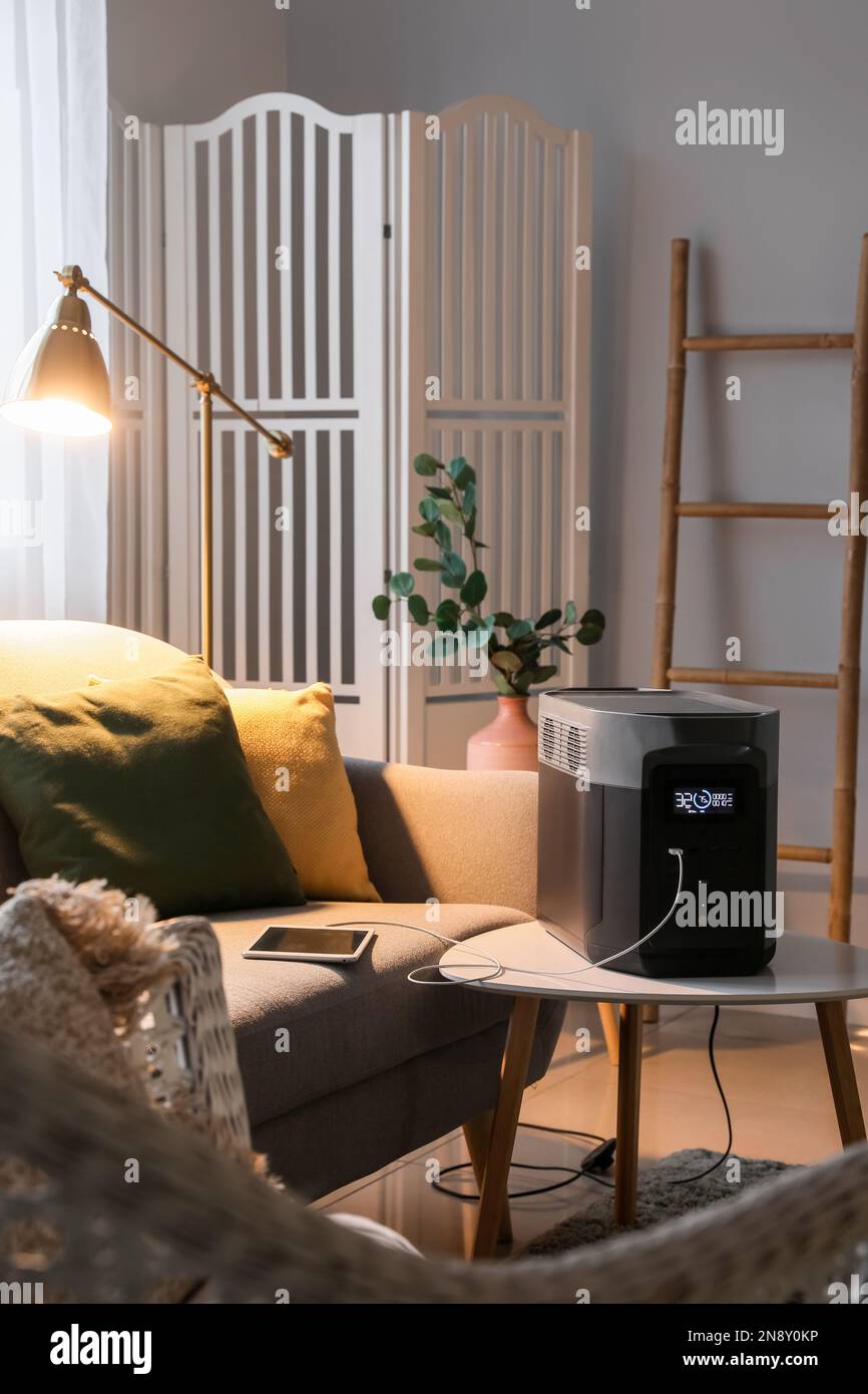 Interior of living room with portable power station and glowing lamp ...