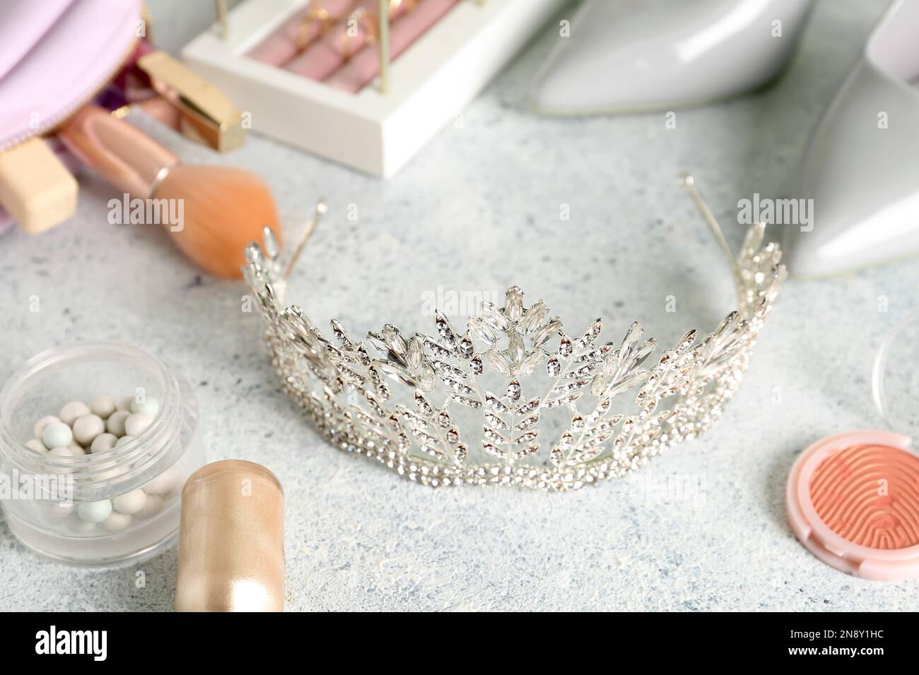 Beautiful tiara and makeup products on grunge table, closeup. Prom ...