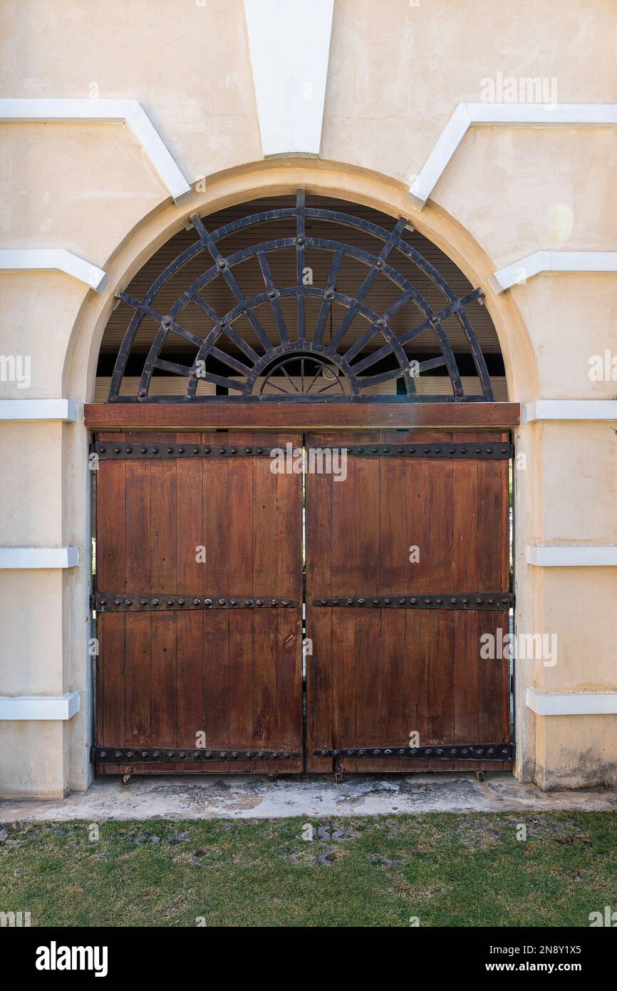 Arched wooden gate on cement wall background Stock Photo - Alamy