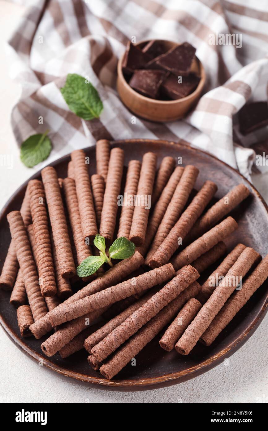 Plate with delicious chocolate wafer rolls on white background Stock ...