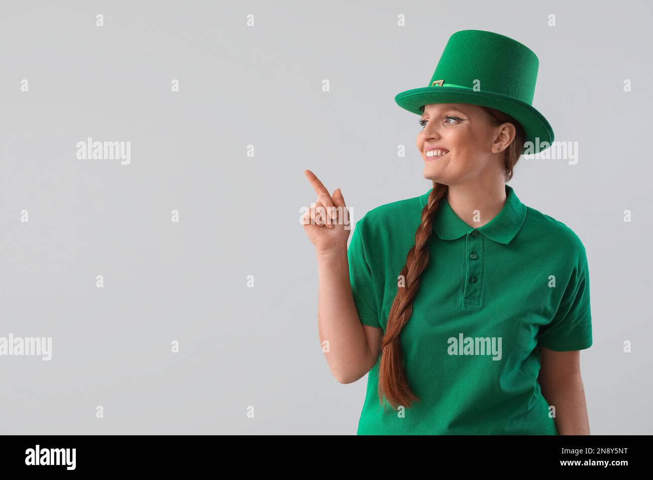 Beautiful redhead woman in hat pointing at something on light ...