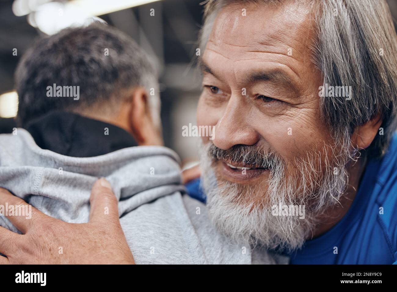 Friends, fitness and Asian man hug in gym for teamwork, support and ...