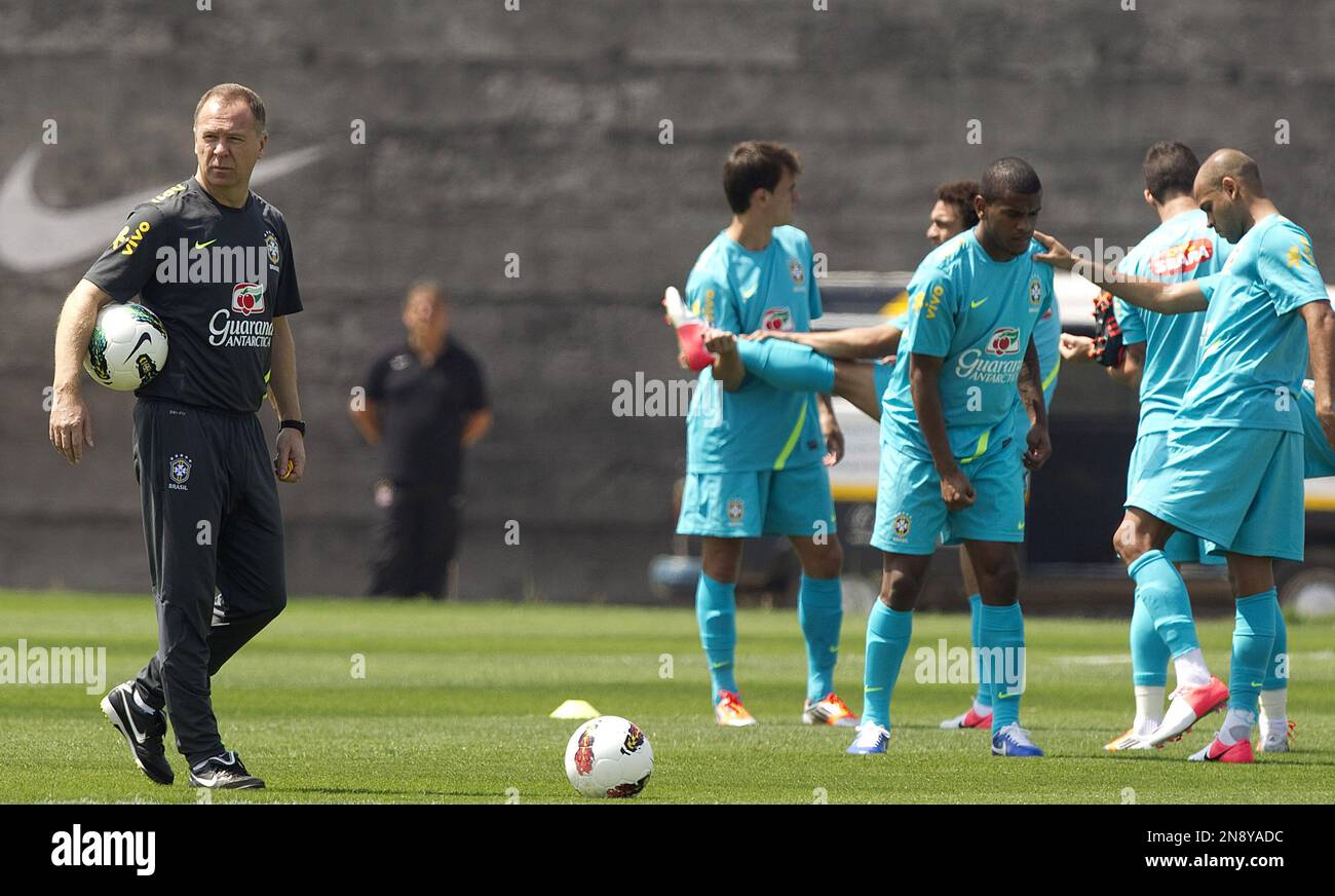 Brazil's coach Mano Menezes, left, walks on the pitch as players ...