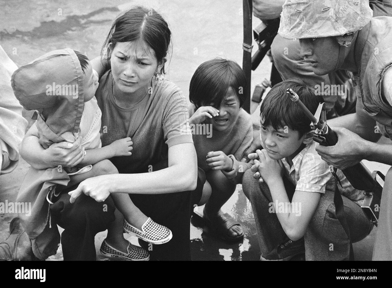 A weeping South Vietnamese mother and her three children are shown on ...
