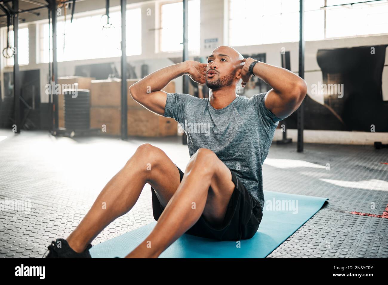 Great posture comes from a strong core. a young man completing crunches ...