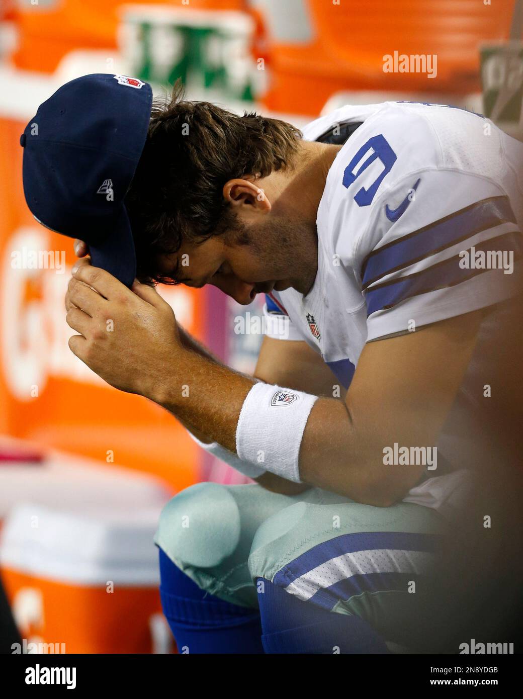 Dallas Cowboys' Tony Romo (9) sits on the bench after throwing his ...