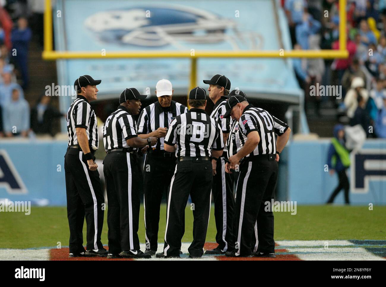 Official confer at midfield during the first half of an NCAA college ...