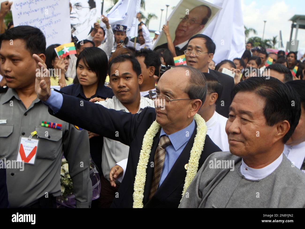Myanmar's President Thein Sein, center, waves to supporters upon his arrival at Yangon ...