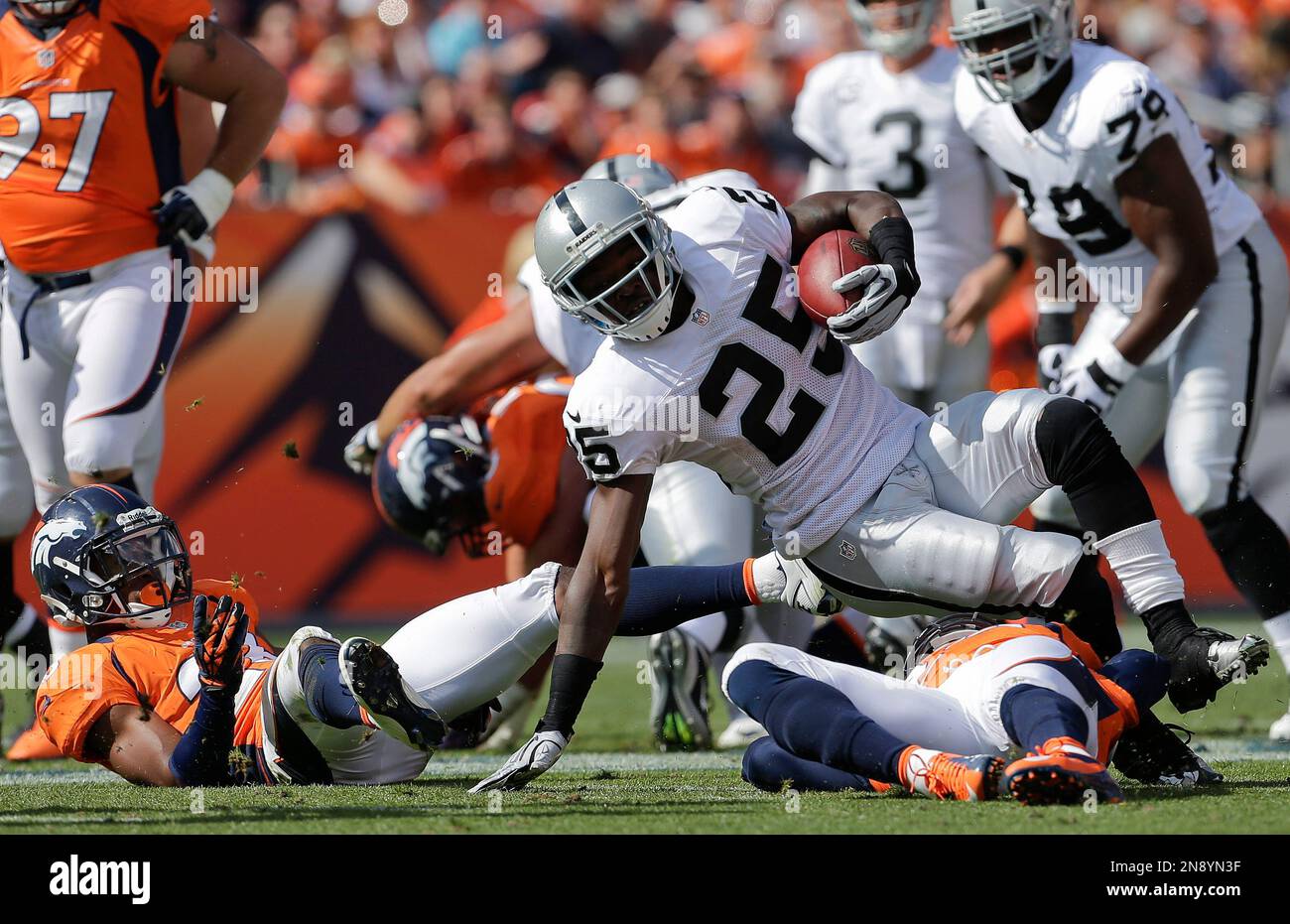 Oakland Raiders running back Mike Goodson (25) is tripped up by the ...
