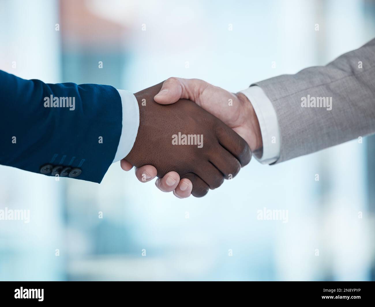 Lets get started. two businessmen shaking hands in a modern office ...