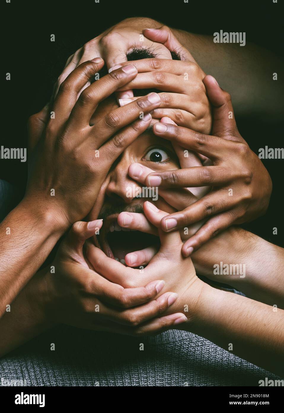 Whats Real And Whats Reality Hands Grabbing A Young Mans Face Against A Dark Background Stock