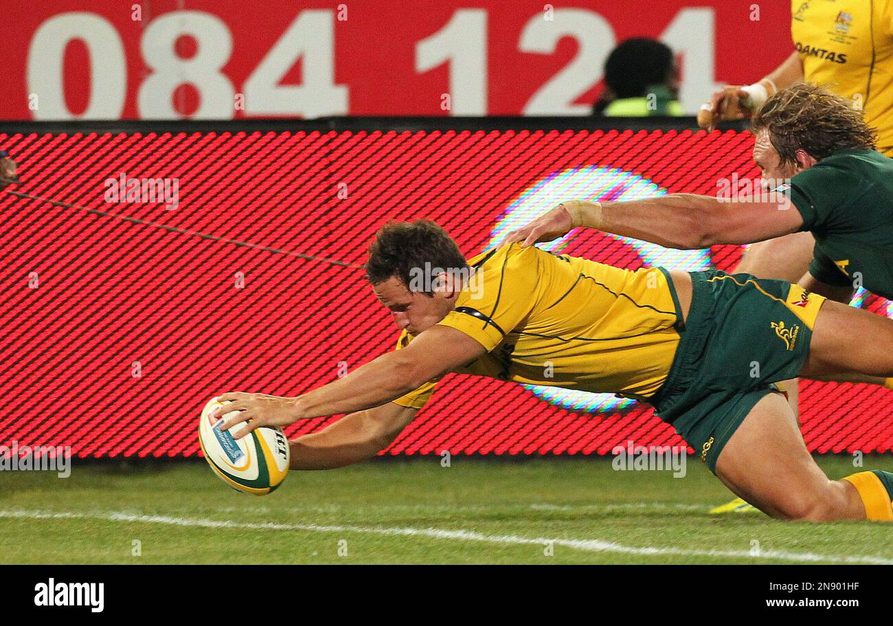 Australia's Mike Harris, left, scores a try as South Africa's Andries ...