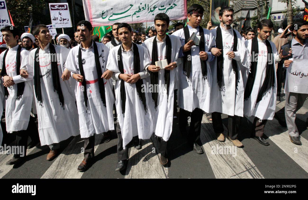 Joining hands, Iranian seminary students hold copies of the Quran, the ...