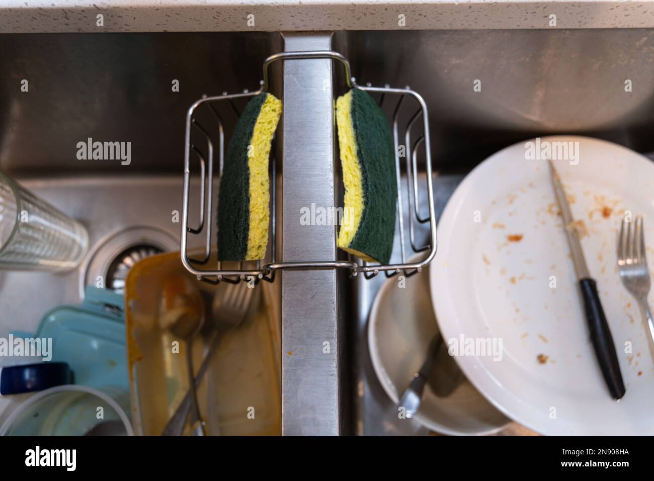 Scrub sponges in a kitchen sink with dirty plates Stock Photo - Alamy