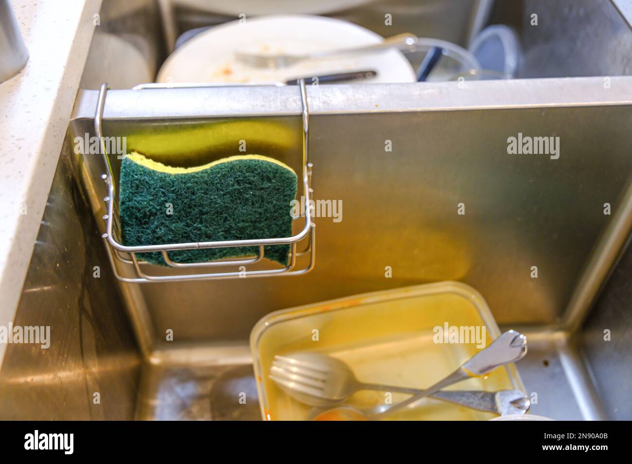 Scrub sponges in a kitchen sink with dirty plates Stock Photo - Alamy