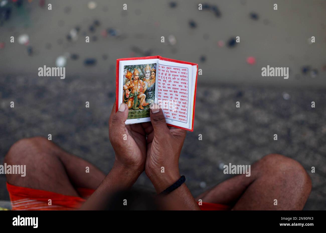 An Indian man reads the Hanuman Chalisa, a Hindu holy scripture, during ...