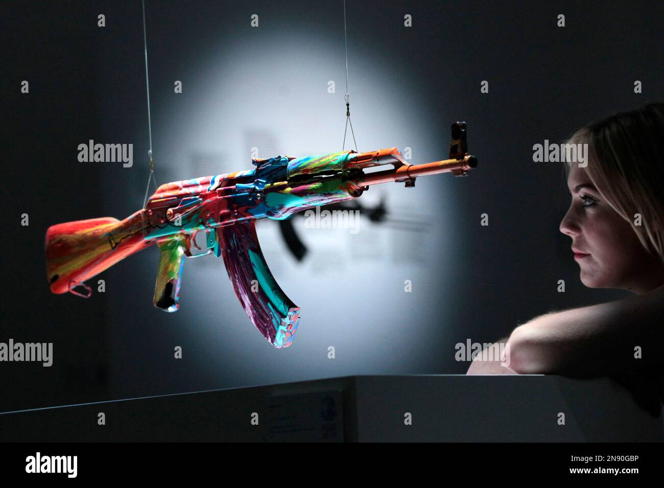 A member of staff poses with an interpretation of an AK-47 assault ...