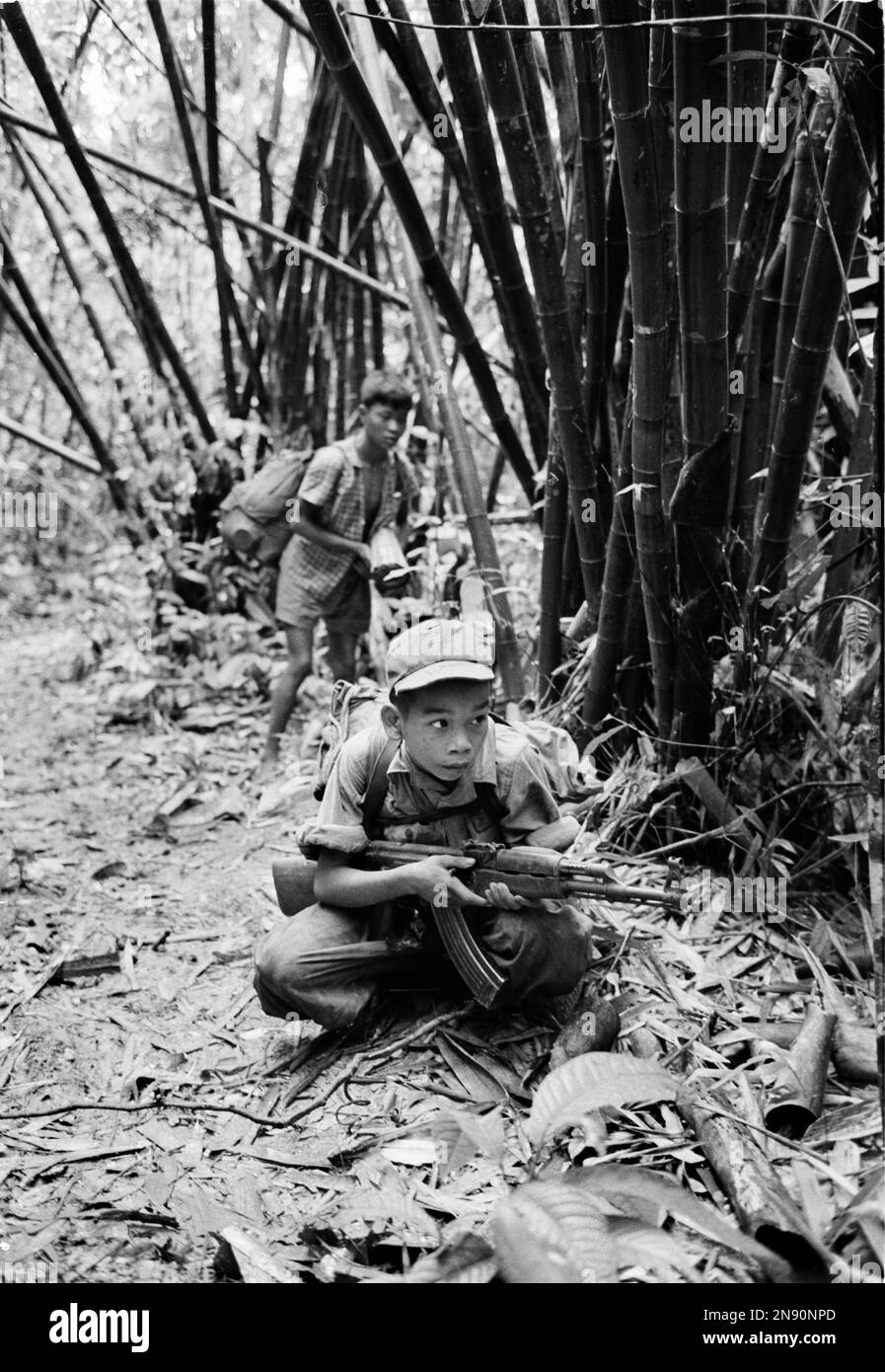 A 14-year-old Montagnard boy points a captured Communist AK-47 rifle ...